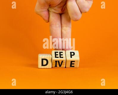 Deep dive symbol. Businessman turns a wooden cube with words 'Deep dive ...