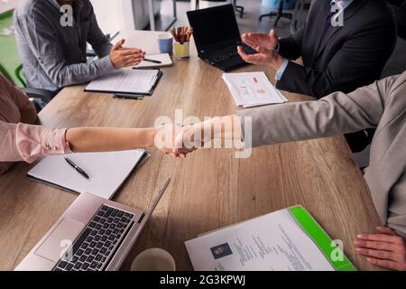 Two business teams sitting at both sides of table in meeting room Stock ...