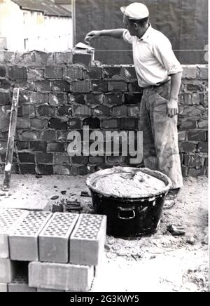 1950s, historical, people on a works outing playing on a beach in their ...