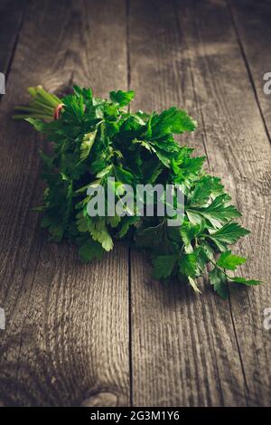 Bunch of parsley stem on a wooden cutting board Stock Photo - Alamy