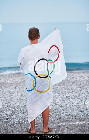 Kemer, Turkey - June 16, 2021: Woman is covered with the Olympic flag ...