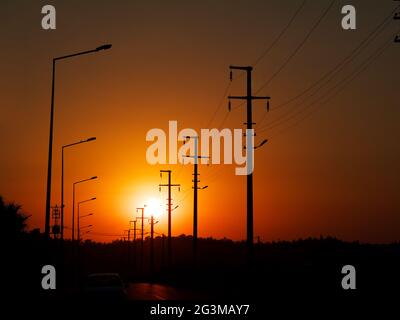 road with power line and lamp posts in sunset Stock Photo - Alamy