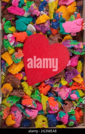 Red color heart shaped object on finger on brown Stock Photo - Alamy