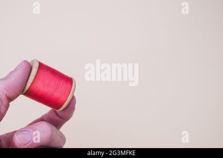 Hand holding linen thread on a white background Stock Photo - Alamy