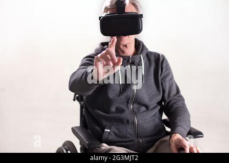 In VR glasses. Disabled man in wheelchair is at home Stock Photo - Alamy