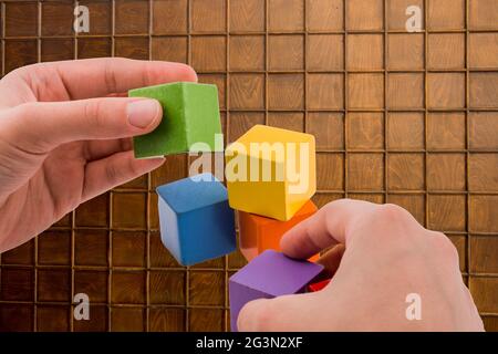 Hand playing with colorful cubes on a white background Stock Photo - Alamy