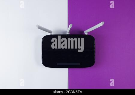 Tried Wi fi router on gray-purple background Stock Photo - Alamy