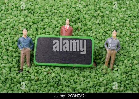 Tiny figurine of man and notice board on sand Stock Photo - Alamy