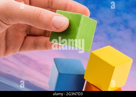 Hand playing with colorful cubes on a white background Stock Photo - Alamy