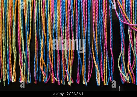 Lots of colorful braided strings on display Stock Photo - Alamy