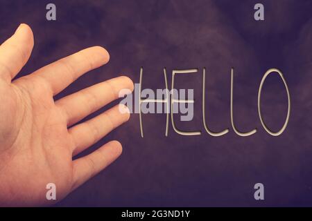 Hand making a hello welcome gesture on dark background Stock Photo - Alamy