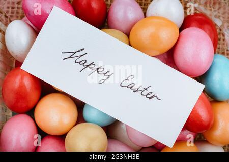 Happy Easter written on a small piece of paper on colorful decorative ...