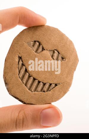 Hand holding a cardboard paper with smiley face Stock Photo - Alamy