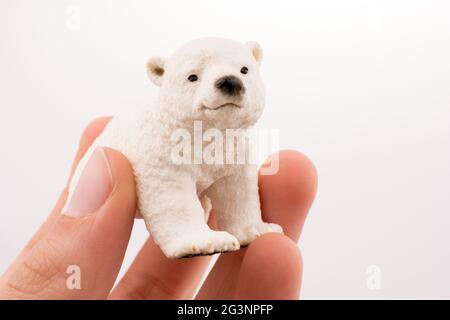 Hand holding a Polar bear model on a wooden background Stock Photo - Alamy