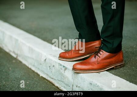 Man's legs in leather boots on a snow background Stock Photo - Alamy