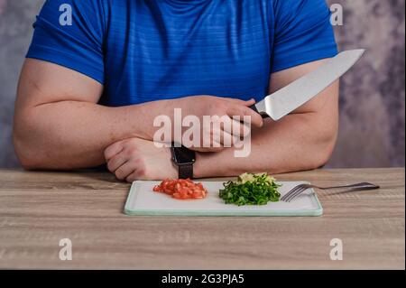 A man cuts green onions on a board. Healthy eating Stock Photo - Alamy