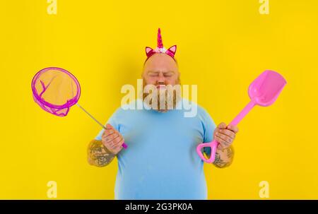 fat man with headband play with sea net and paddle Stock Photo - Alamy
