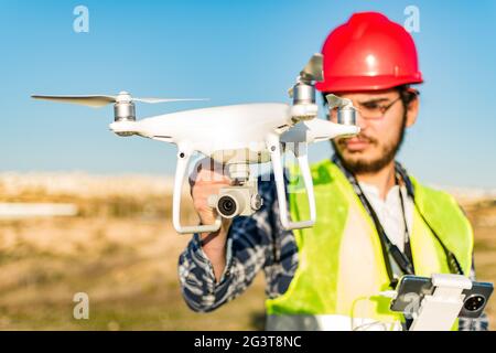 Drone inspection. Operator inspecting construction site flying with ...