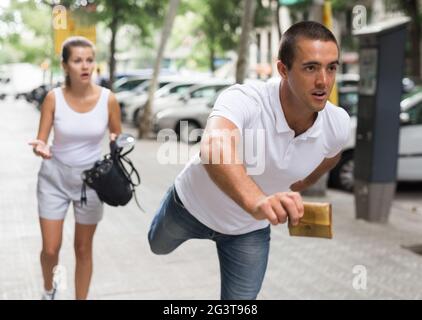 Man running away with stolen wallet Stock Photo - Alamy