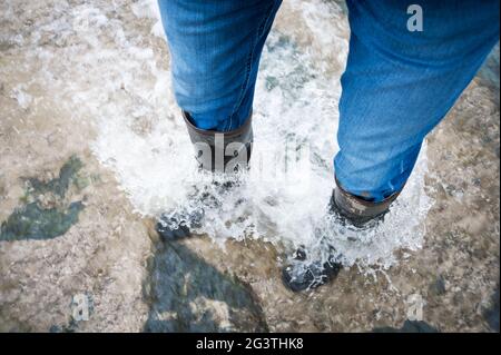 Standing in floating water with rubber boots Stock Photo - Alamy
