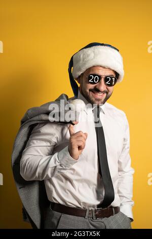 Handsome bearded man wearing Christmas hat holding gift box with red ...