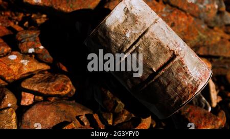 Rusty destroyed metal barrel on beach rocks Stock Photo - Alamy