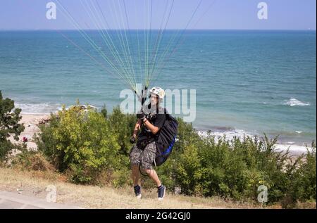 Paraglider pilot in the process of taking off on the beach Stock Photo ...