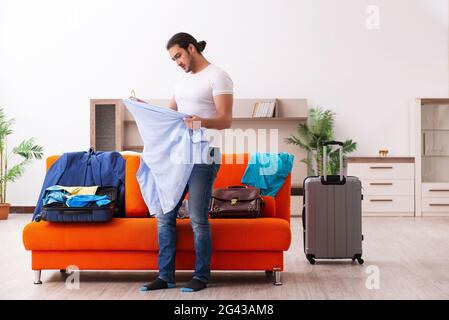 Young male student preparing for trip at home Stock Photo - Alamy