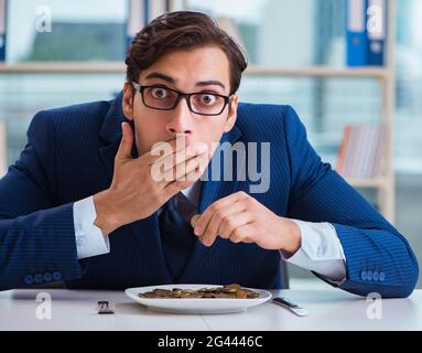 Funny businessman eating gold coins in office Stock Photo - Alamy