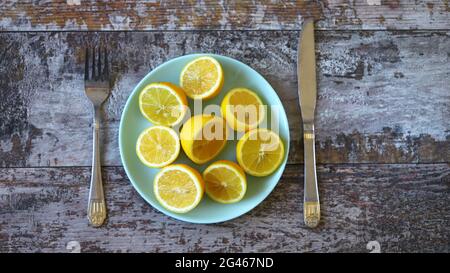 Plate with fresh lemons. Halved lemons on a plate. Vitamins concept ...