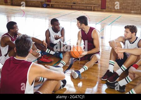 Basketball players interacting while relaxing Stock Photo - Alamy