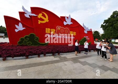 Pupils wearing red scarves shoot videos before a sign marking the 100th ...