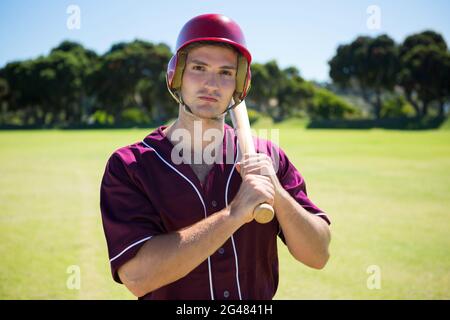 athlete holding green baseball bat behind neck Stock Photo - Alamy
