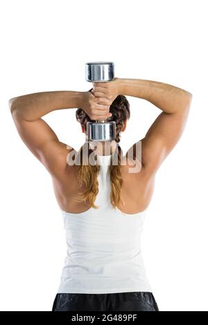 Rear view of rugby player exercising while kneeling on grassy field ...