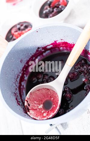 Preparing mixed berry compote from frozen berries in a nonstick cooking ...