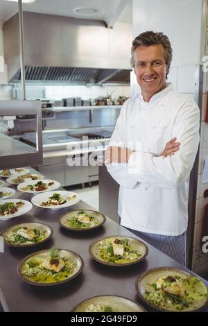 Portrait of happy chef with appetizer plates at order station Stock ...