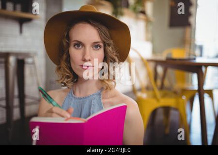 Medium shot of serious pretty young woman sitting on yellow bench on ...