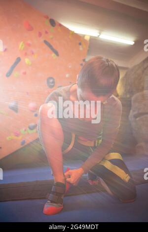 Determined woman preparing for rock climbing in fitness studio Stock ...