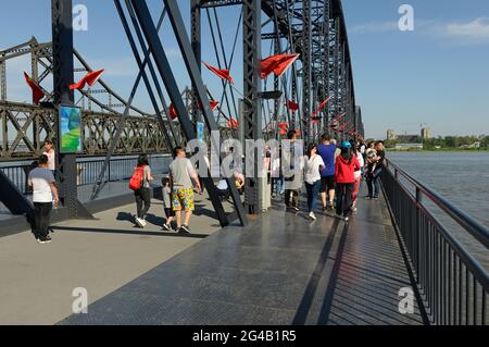Many visitors on the old, bomb-damaged, bridge across the Yalu river ...