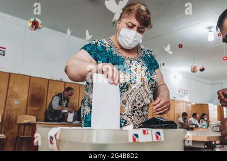 Yerevan, Armenia. 20th June, 2021. A voter casts her vote at a polling ...