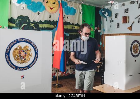 Yerevan, Armenia. 20th June, 2021. A voter casts her vote at a polling ...