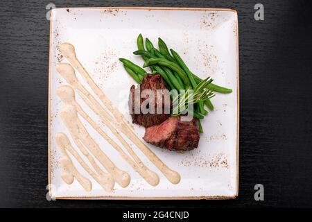 Filet mignon with asparagus on a light plate Stock Photo - Alamy