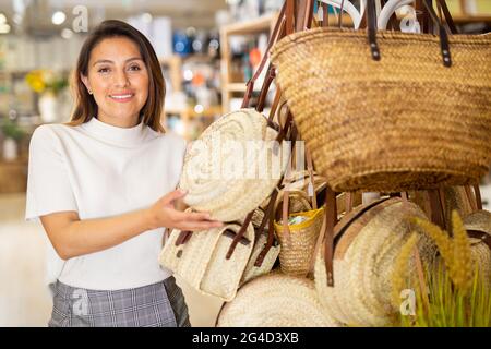 Latino american woman choosing wicker baskets in shop Stock Photo - Alamy
