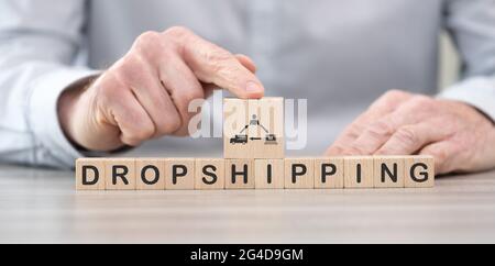 Wooden blocks with symbol of dropshipping concept on blue background ...