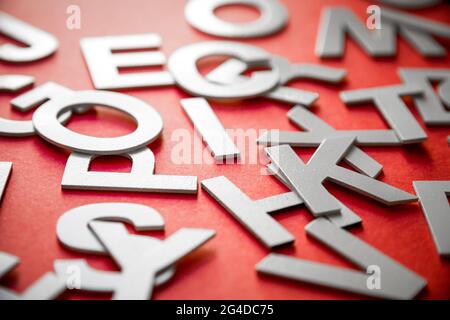 Mixed solid letters pile close up view photo. Education concept on red ...