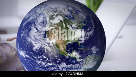 Close up of globe against mid section of person using laptop Stock ...