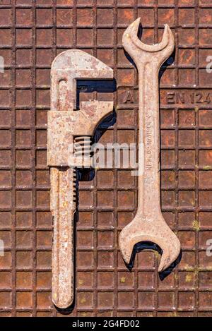 Old wrenches, rolling fork wrench or Englishman, rusty tool on wet ...