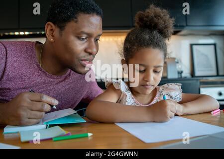 A father helping her daughter with homeschool Stock Photo - Alamy