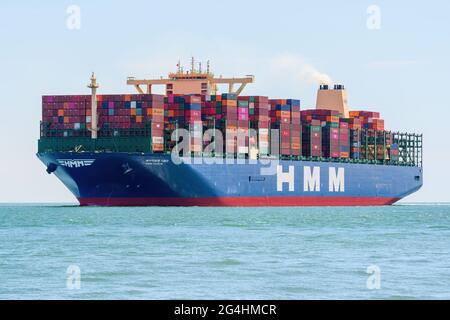 A large ONE container ship and an HMM cargo ship navigate Qingdao Port ...