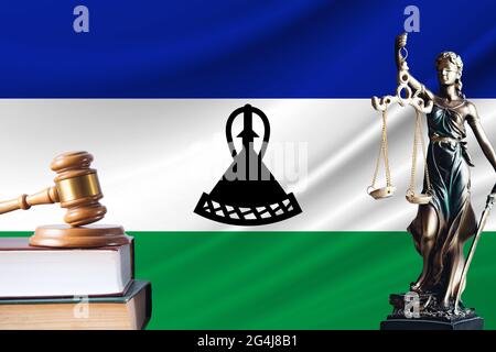 Lesotho flag with statue of lady justice and judicial scales in dark ...